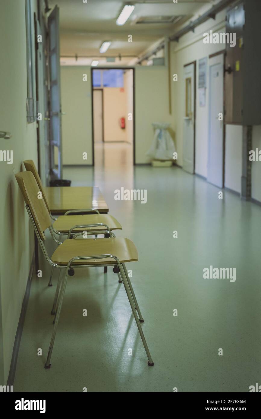 Waiting place in an old hallway of a hospital. Wooden and metal chairs ...