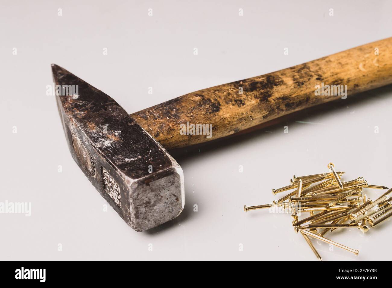 A used and worn european style hammer with a wooden handle and metal ...