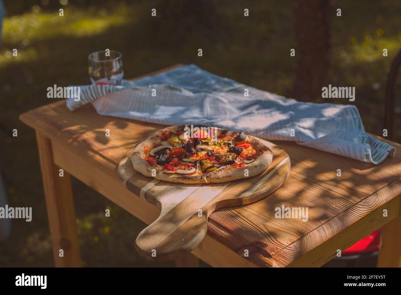 Home made pizza freshly baked and served on a wooden plate on a ...