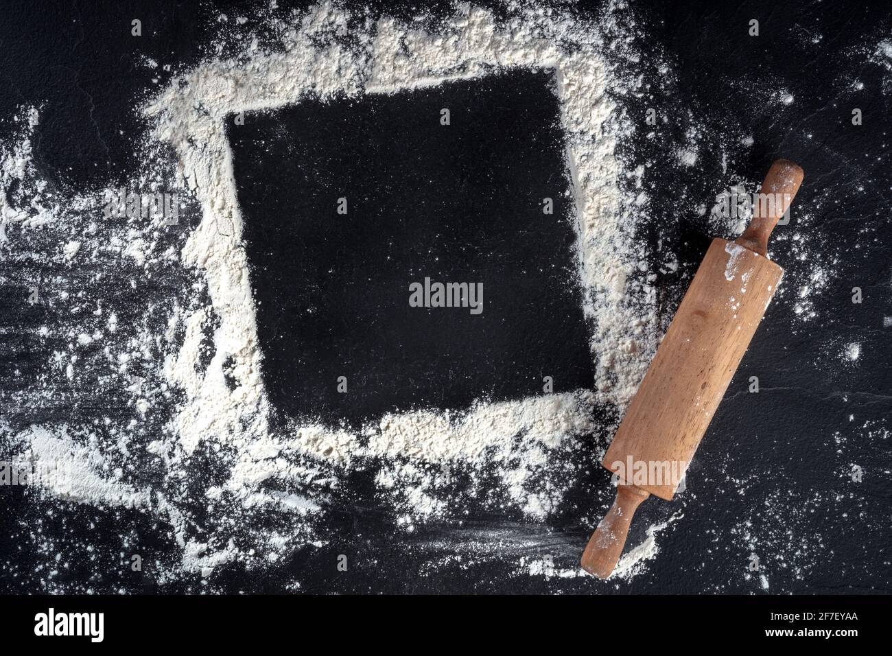 Baking frame with copy space, white flour and a wooden rolling pin ...