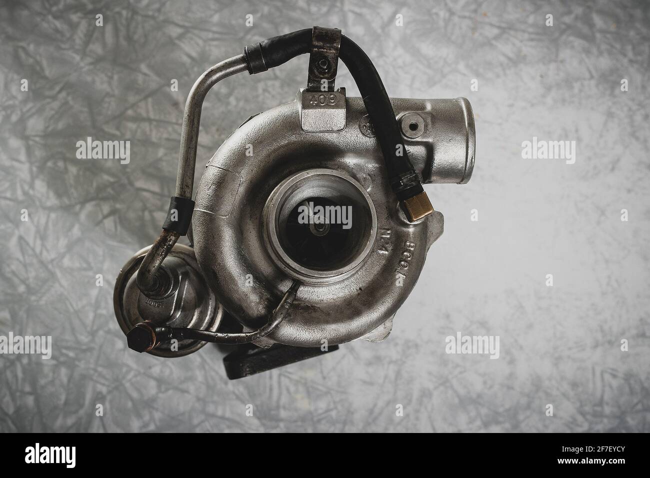 An old reconditioned car turbine, turbocharger, on a working table with ...