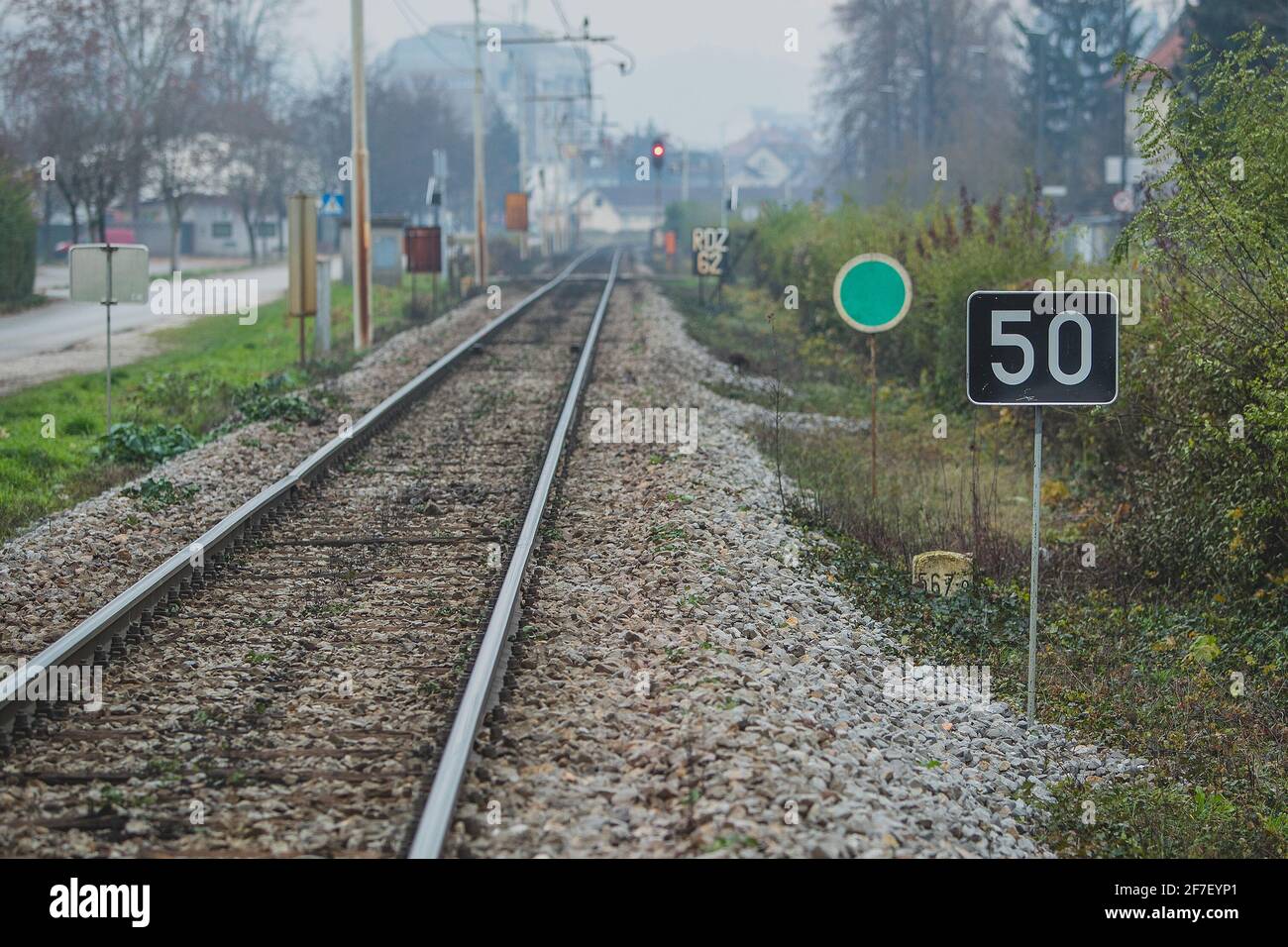 Signs on an open single track railway line with board for 50 km/h limit ...