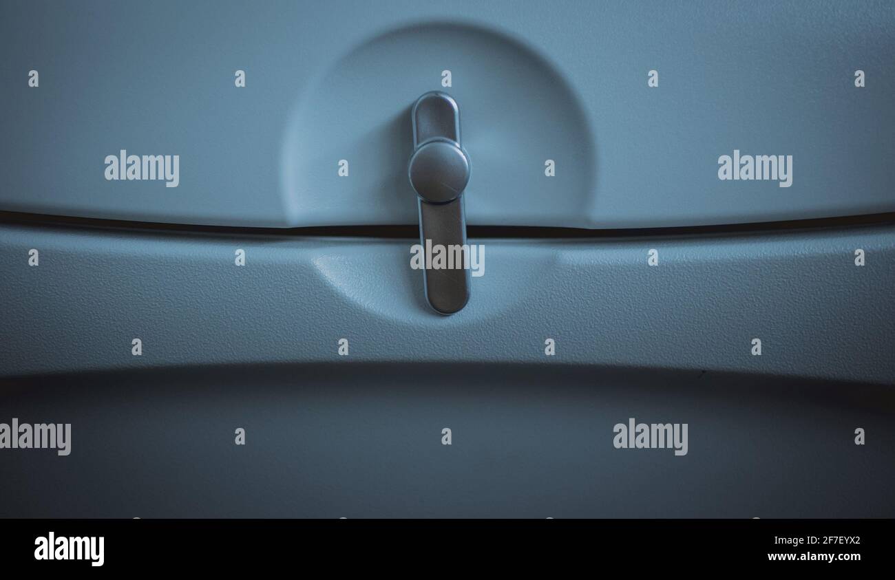 Knob for releasing table tray on an aeroplane seat backrest. Visible ...