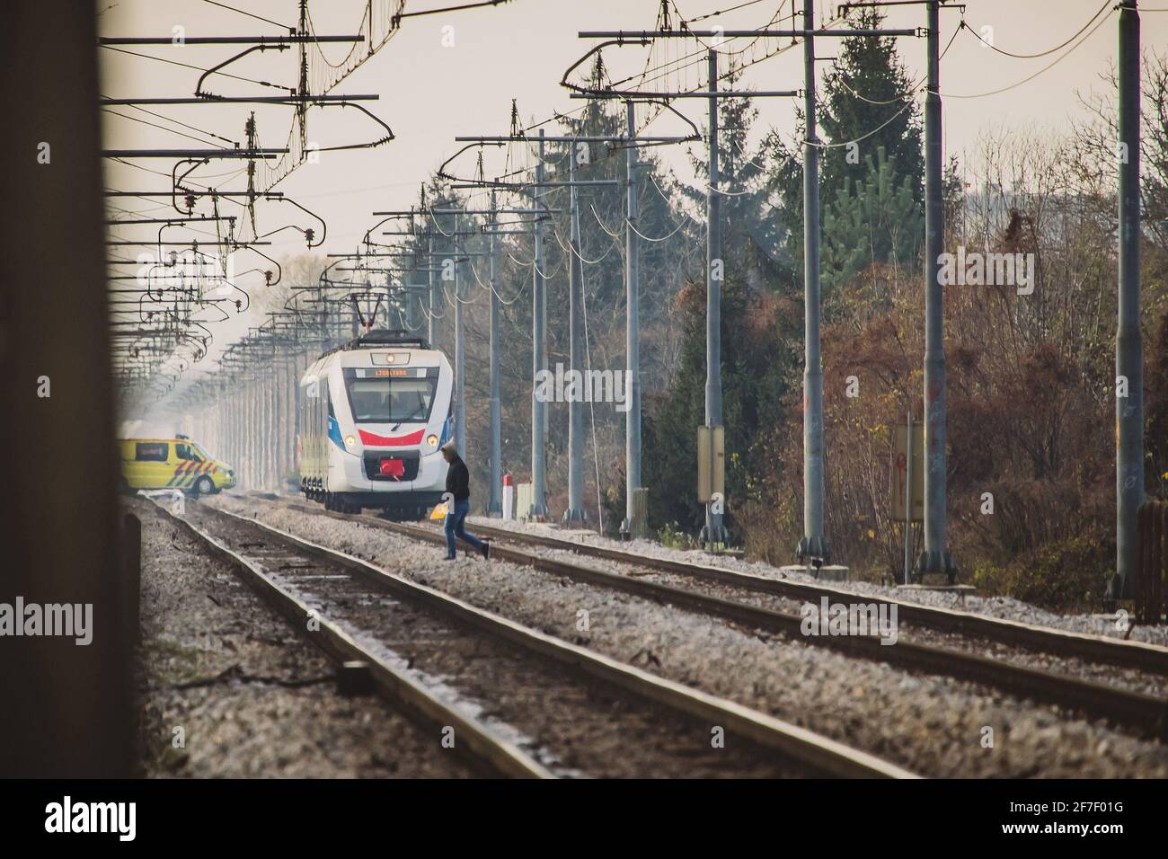 Man ignorantly walking over train tracks with approaching white ...