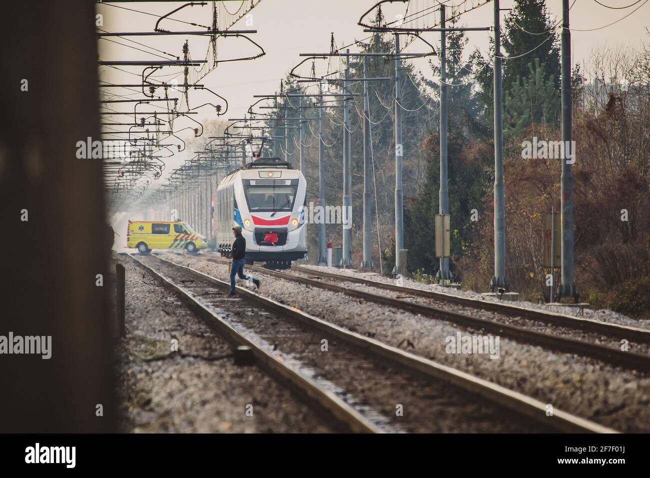 Man ignorantly walking over train tracks with approaching white ...