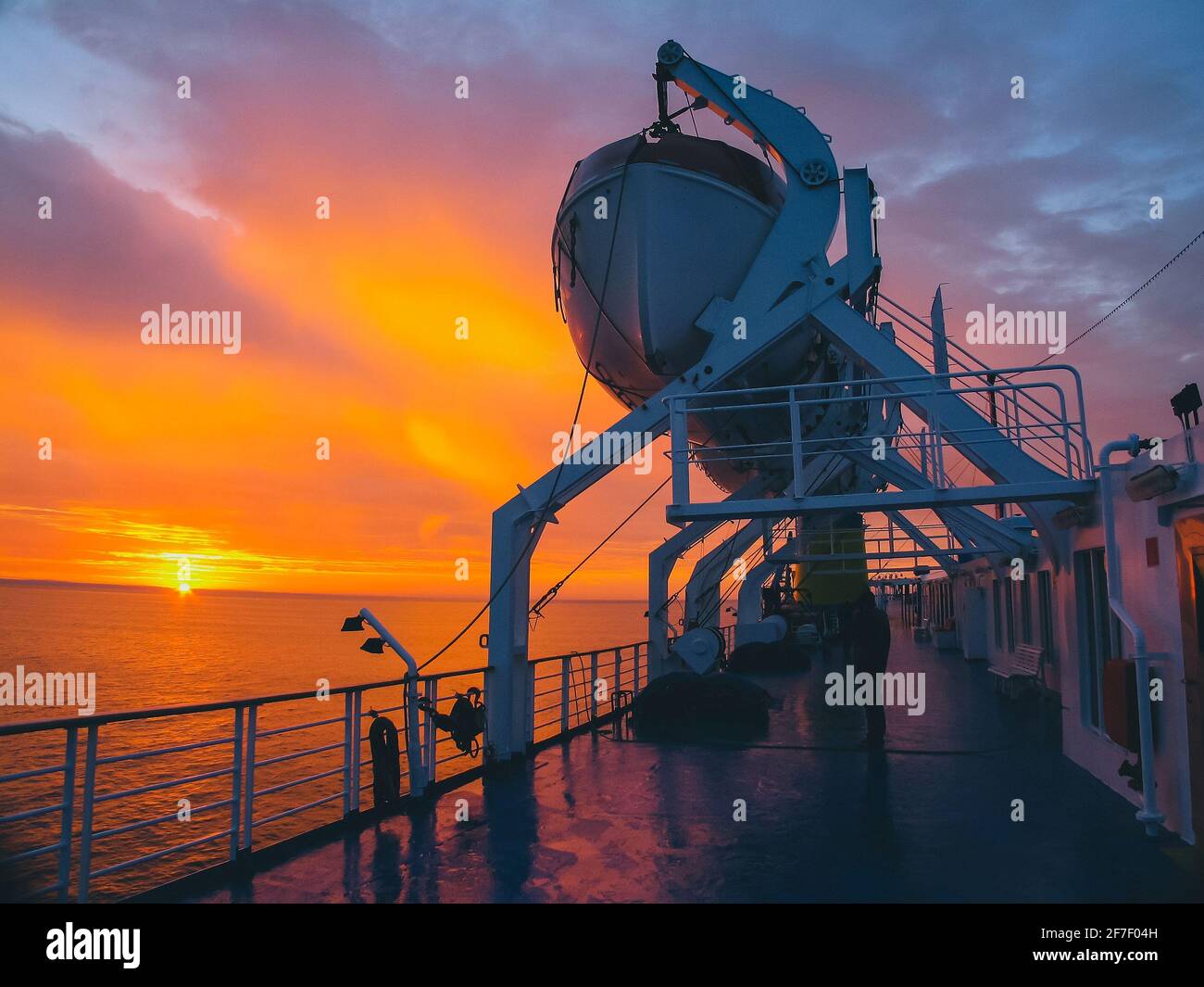 Lifeboat on a cruise ship or ferry at a romantic evening sunset setting ...