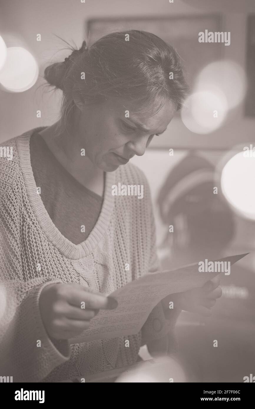 Curious woman reading paper documents obtained from a metal case. Woman ...