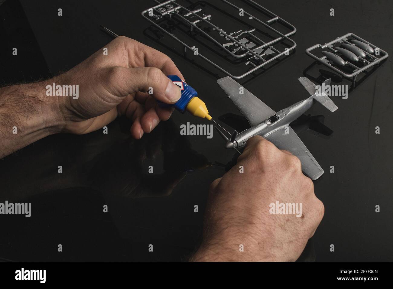 Detail of assembly of plastic model aeroplane resin kit with glue ...
