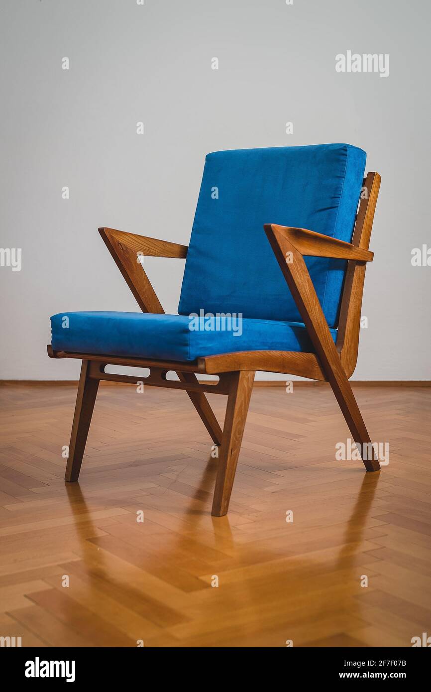 Wooden chair with blue padding, standing on a wooden floor and in front ...