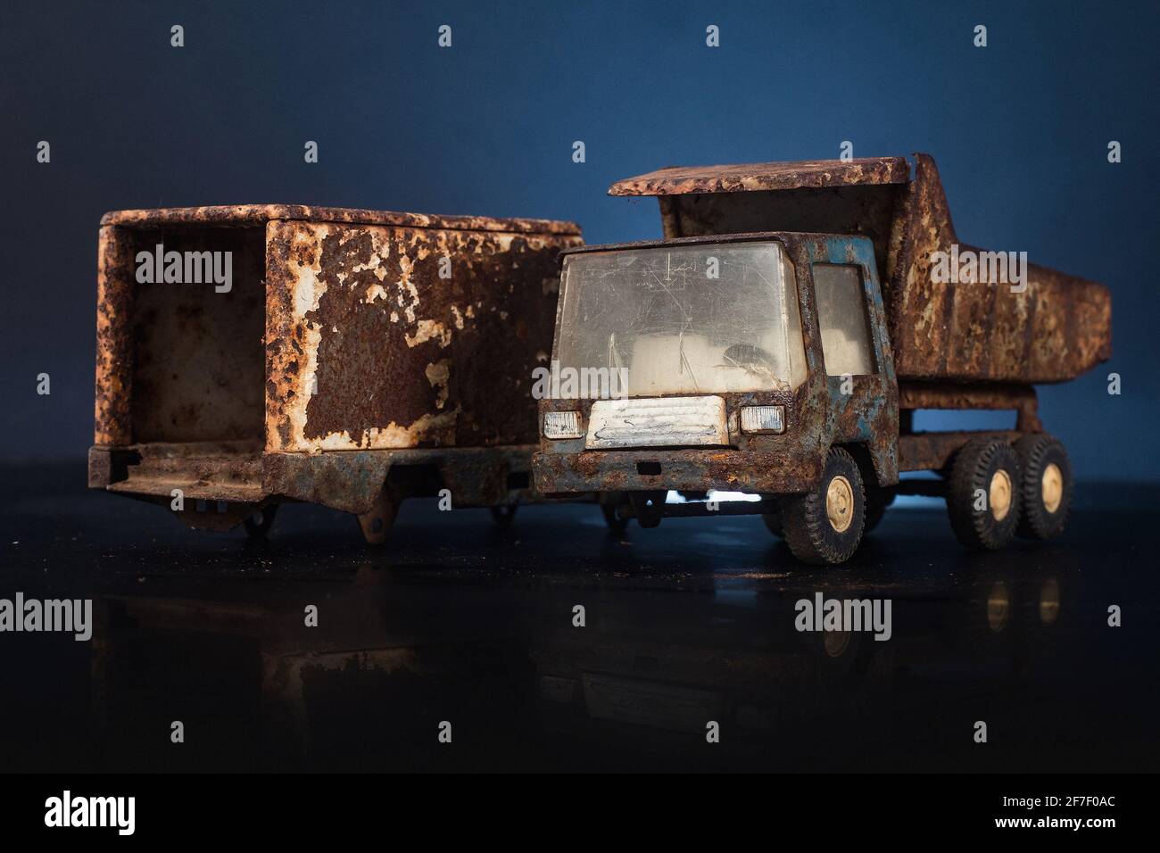 Pair of old, dirty and very rusty tin metal models of toy trucks in ...