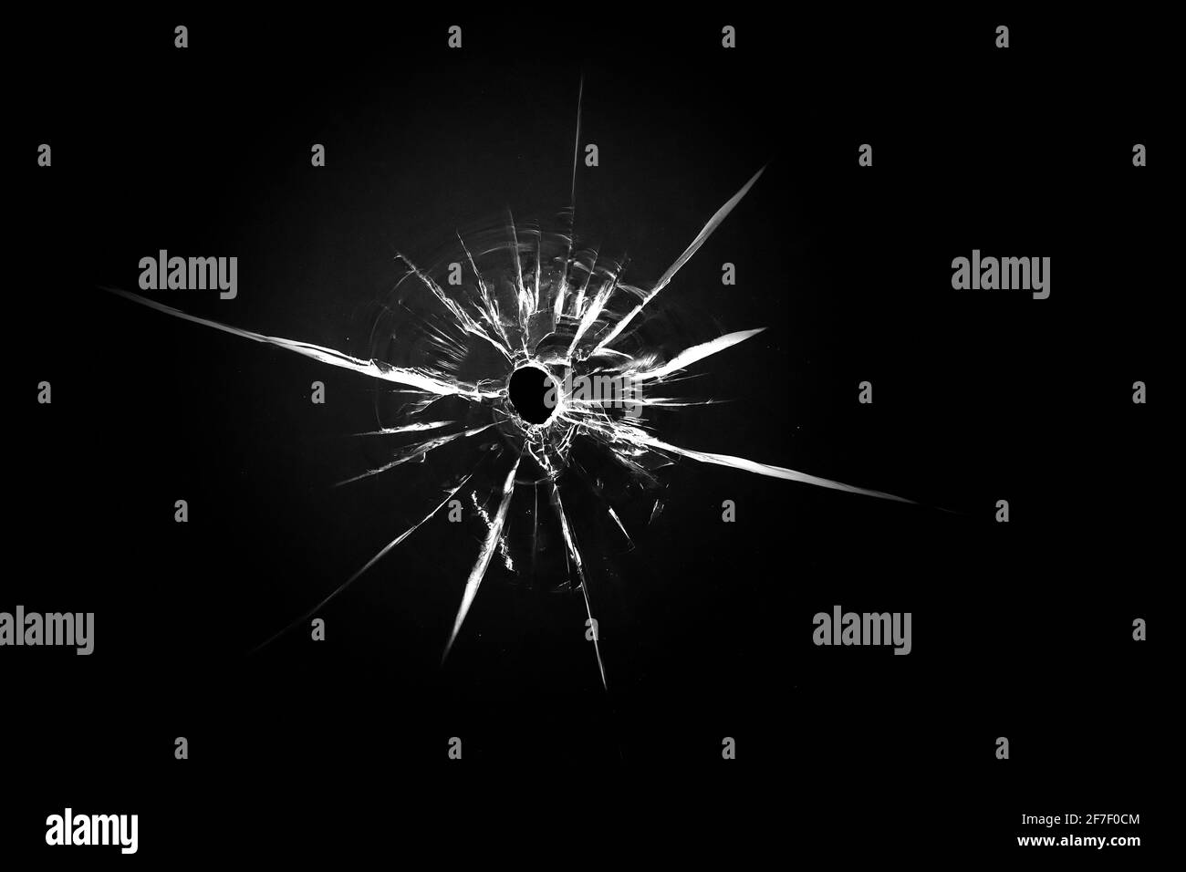 Cracked texture on a black background. Broken glass bullet from a shot ...