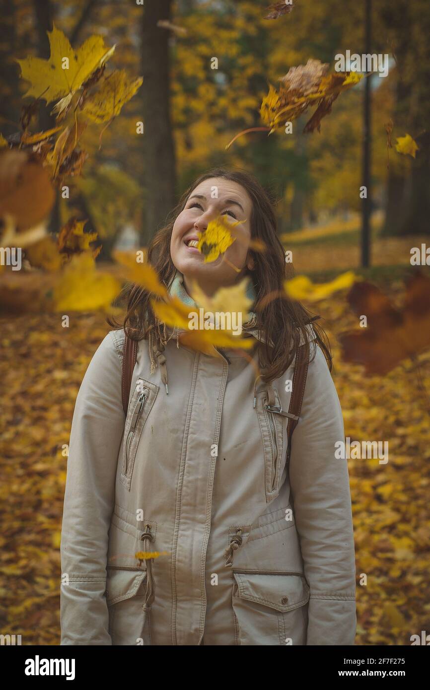 Woman throwing autumn leaves in theair in romantic forest. Cute ...