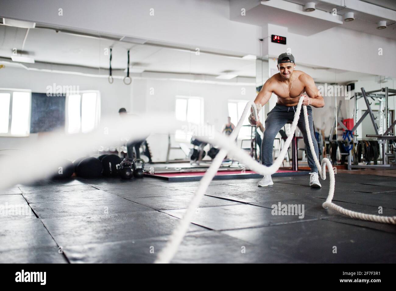 Fit and muscular arabian man working out with heavy ropes in gym Stock ...