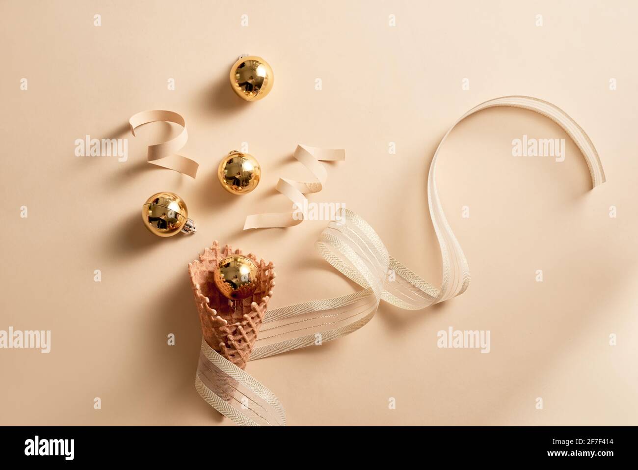 Ice cream waffle cone with ribbon and balls ornament topping. Skin ...