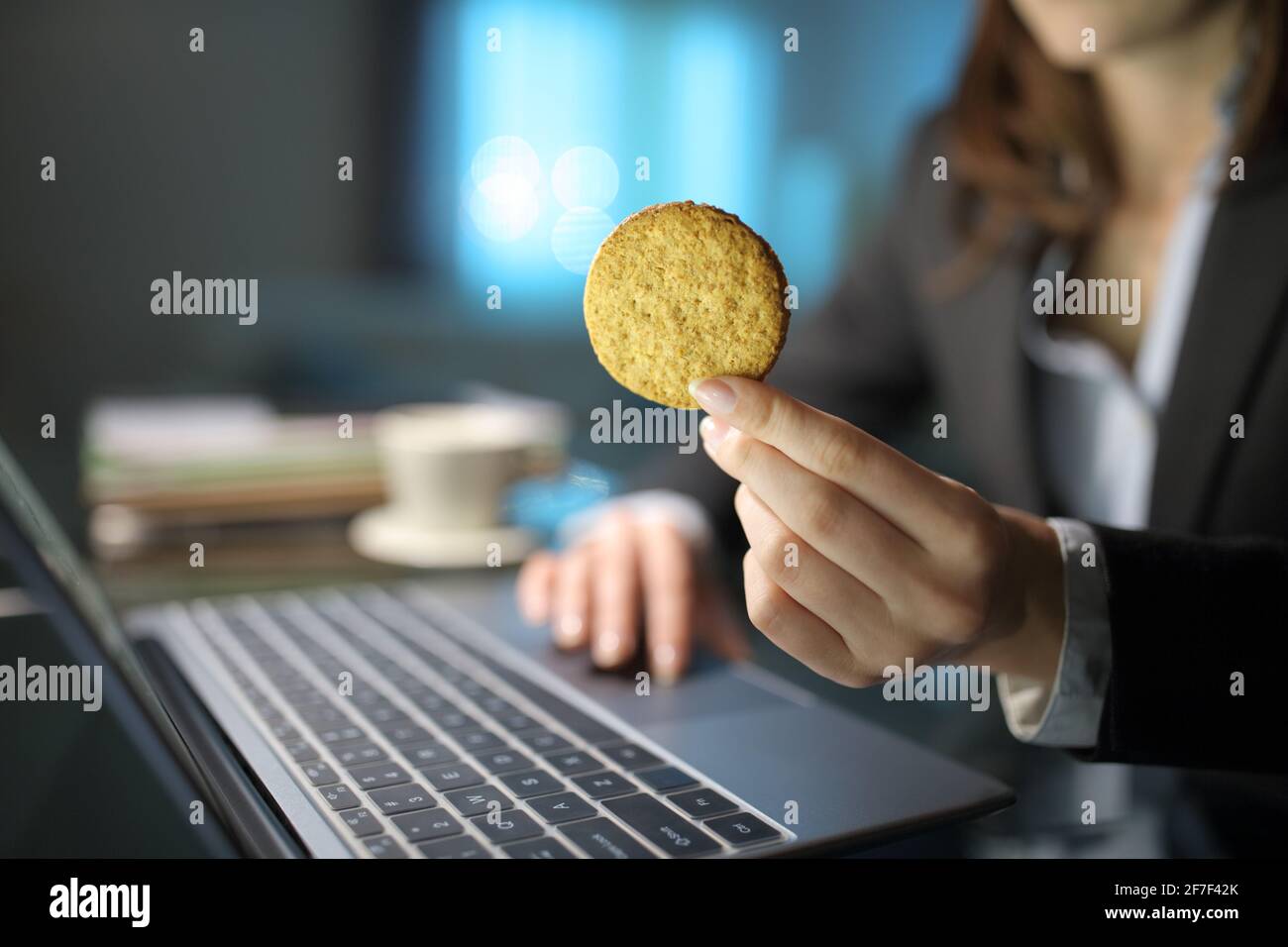 Woman eating biscuit in office hi-res stock photography and images - Alamy