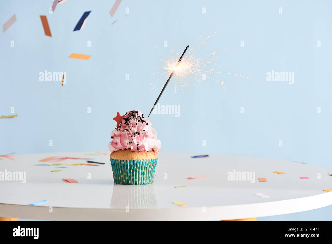 Single sparkler on cupcake blue wal Stock Photo - Alamy