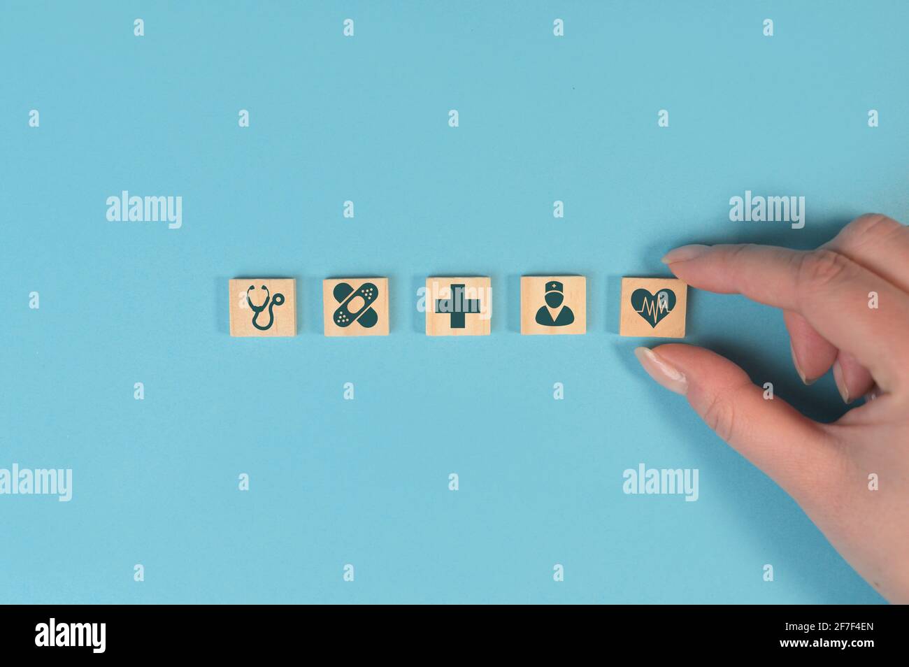 Hand holding wooden blocks with healthcare medical icons on blue ...