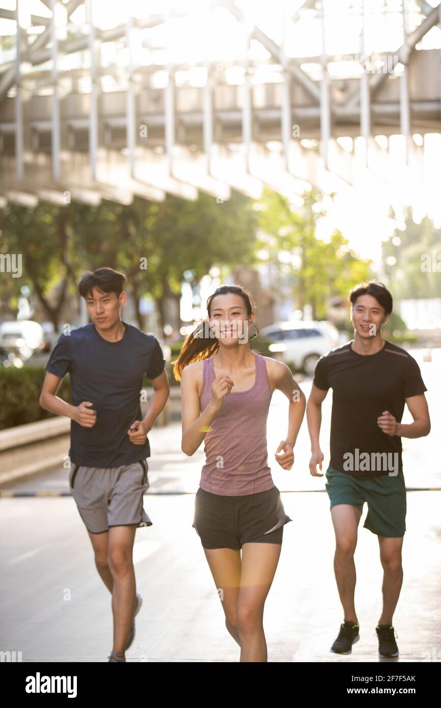 Young friends running outdoors Stock Photo - Alamy