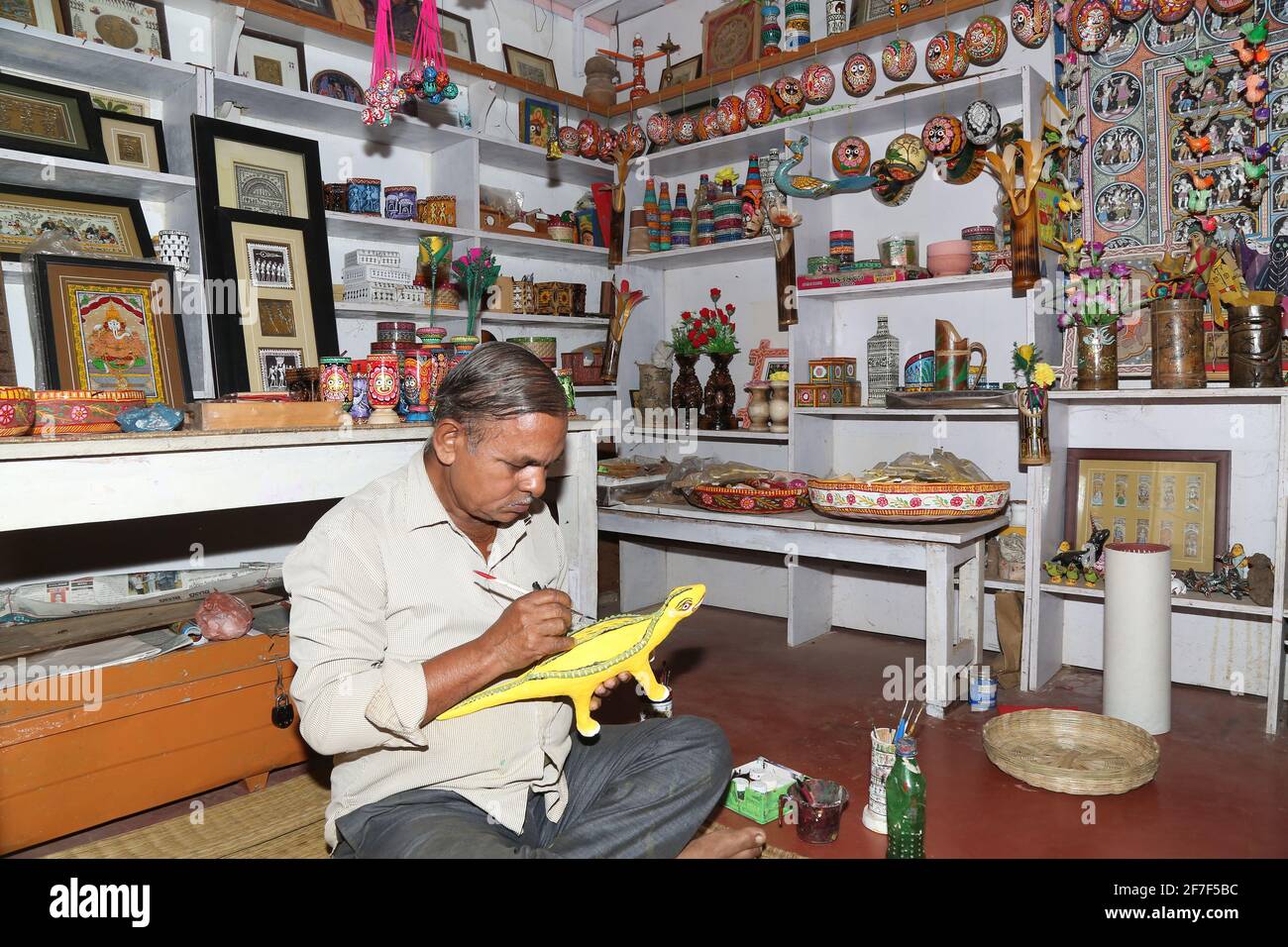 Tribal artisan coloring handmade wooden gift artifacts in Raghurajpur ...