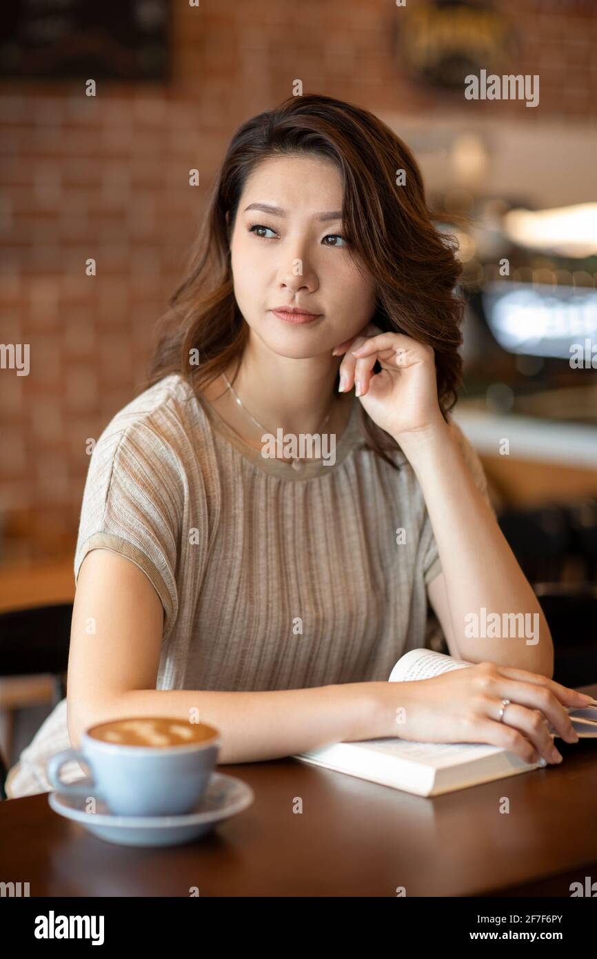 Elegant woman enjoying coffee in cafe Stock Photo - Alamy