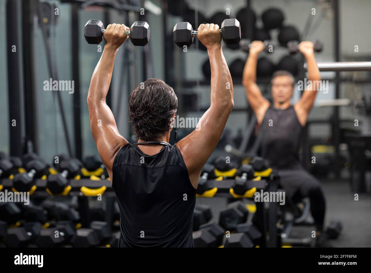 Mature man working out with hand weights at gym Stock Photo - Alamy