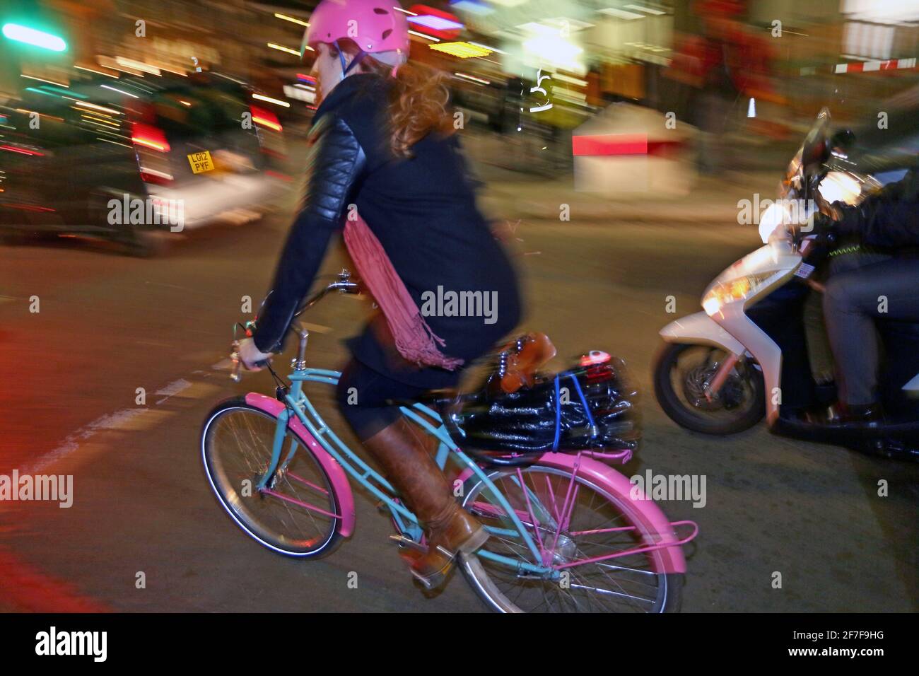 Female cyclist riding in the night on streets of London , UK Stock ...