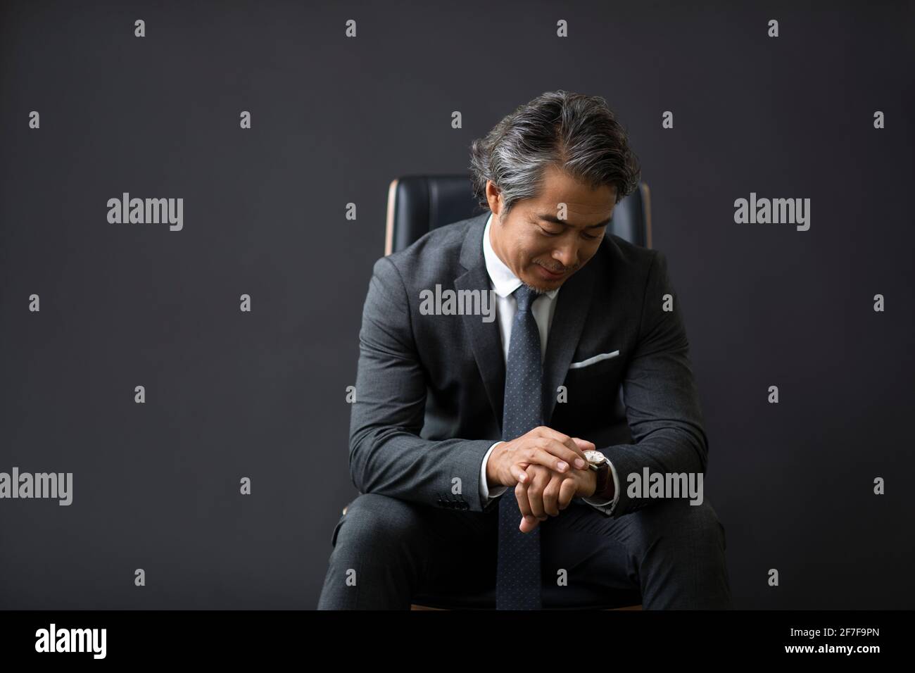 Businessman sitting checking watch smiling hi-res stock photography and ...