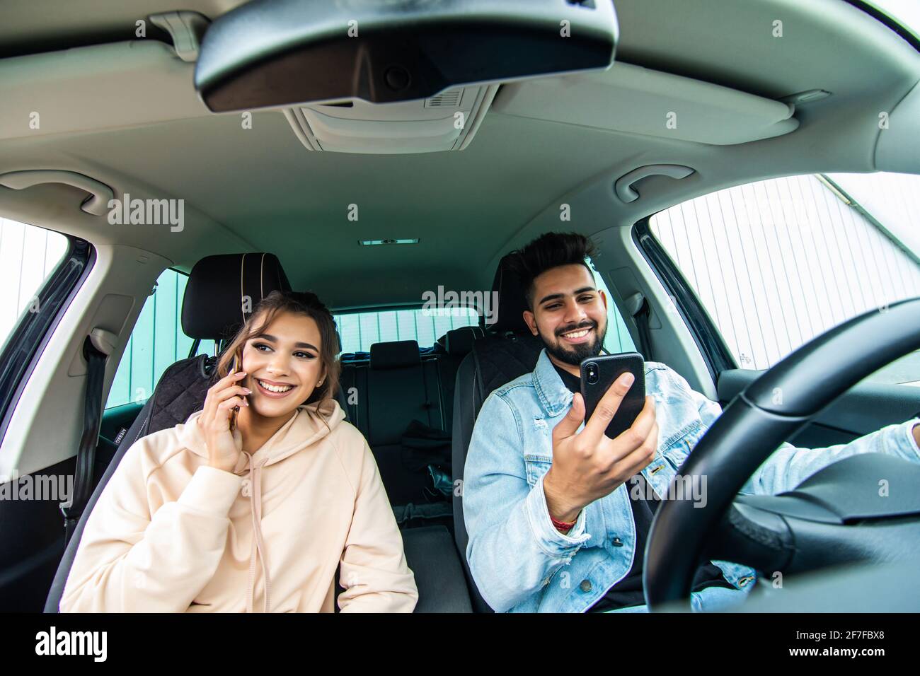 Young couple on the red car, man using moblie phone in a car Stock ...