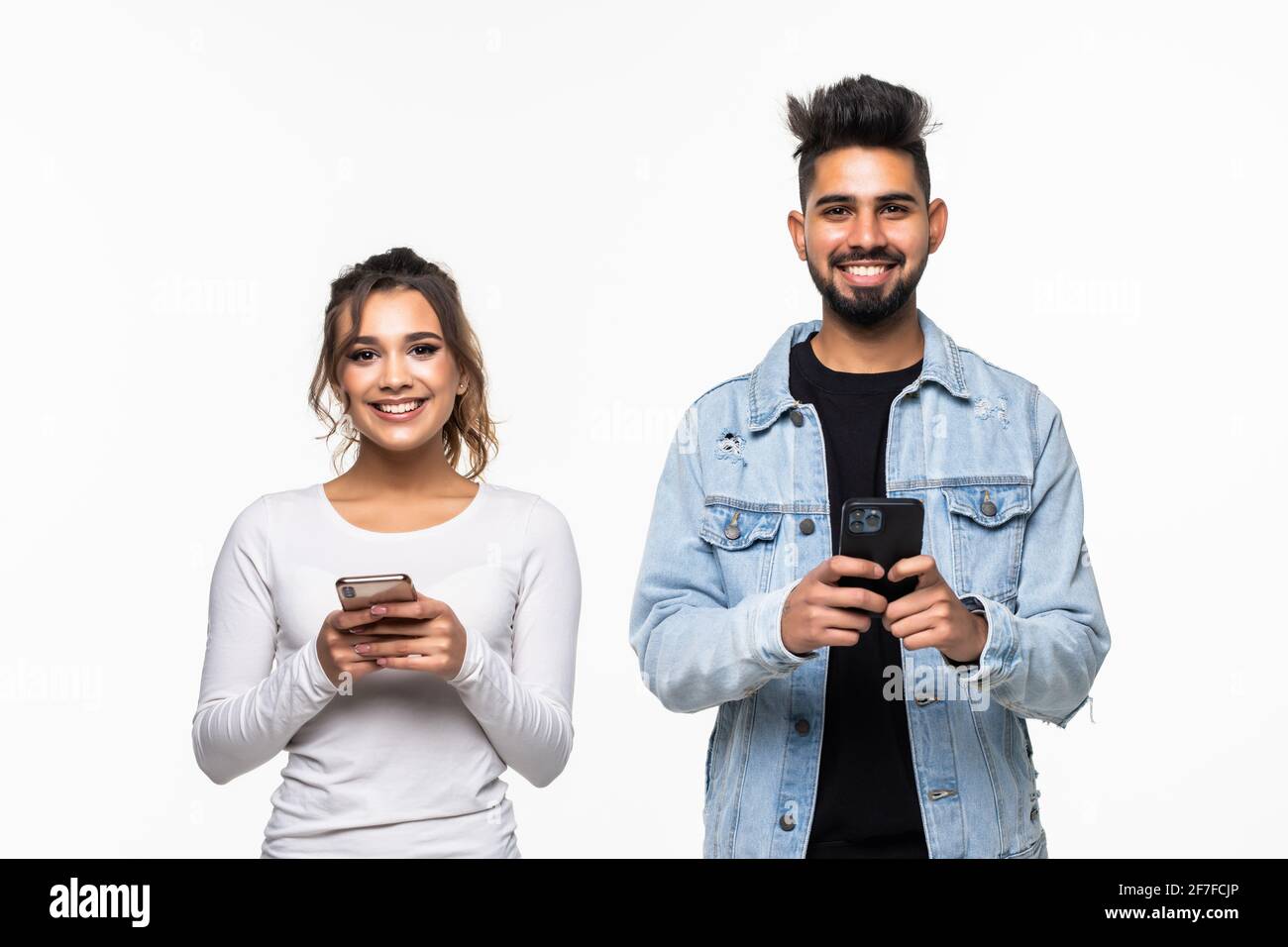 Happy couple sending text messages on white background Stock Photo - Alamy