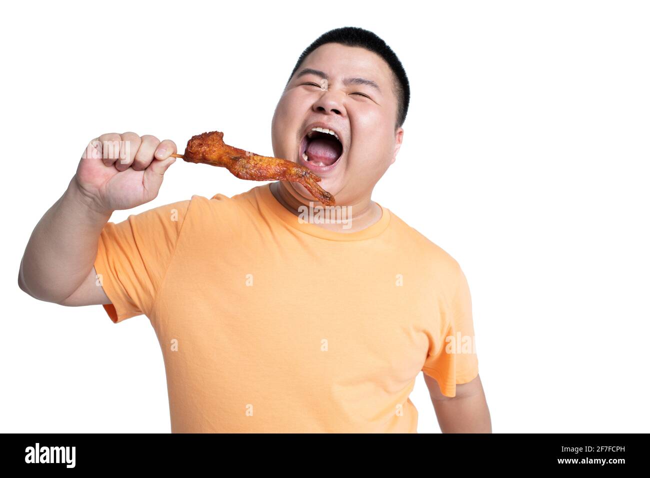 Young man eating fried food Stock Photo - Alamy