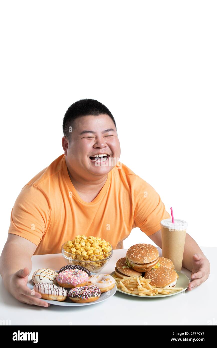 Young man eating fast food Stock Photo - Alamy