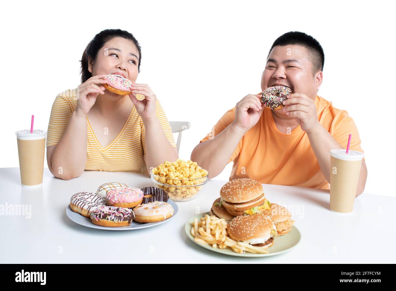 Young couple eating donuts Stock Photo - Alamy