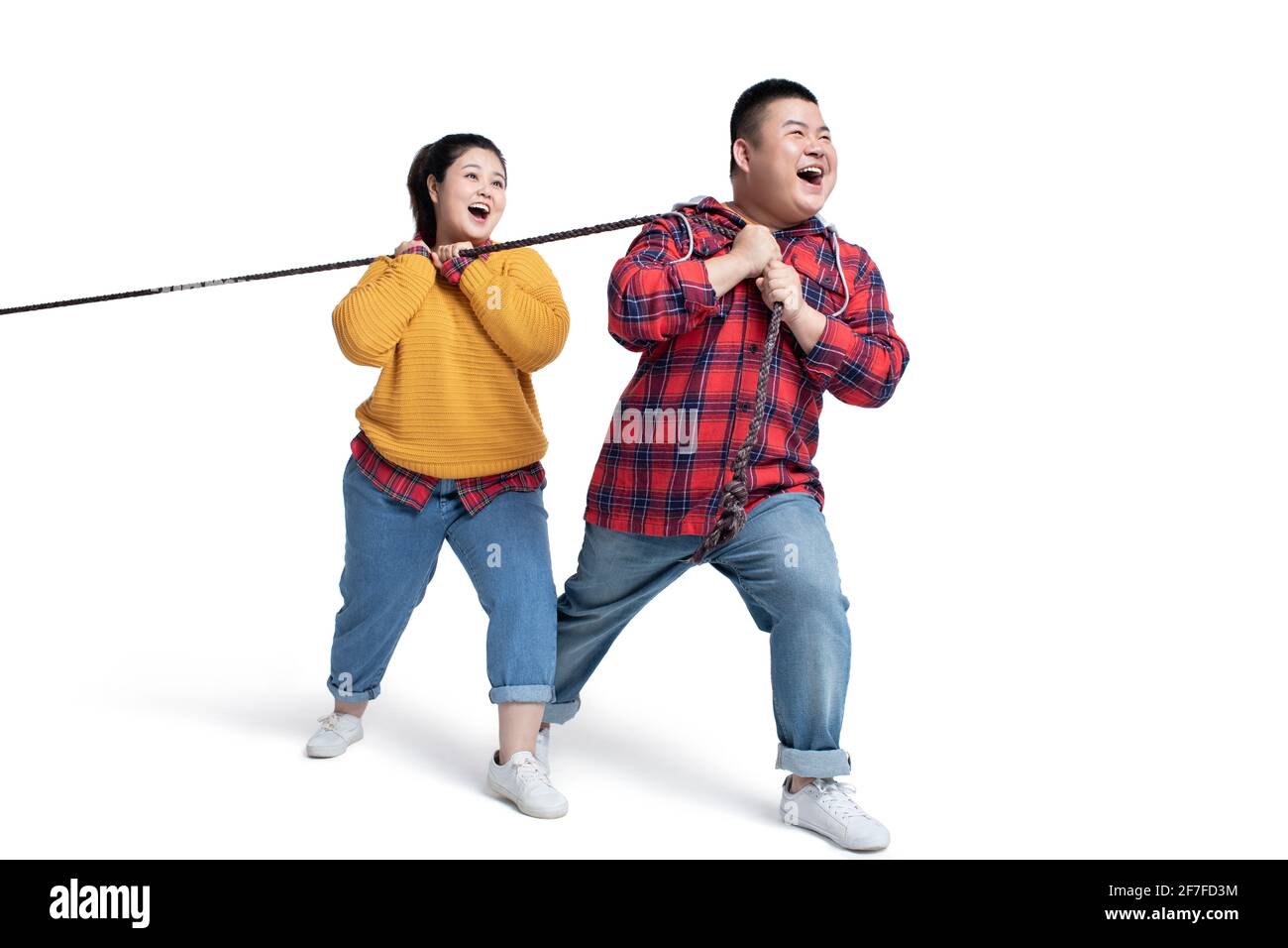 Young couple pulling rope Stock Photo - Alamy