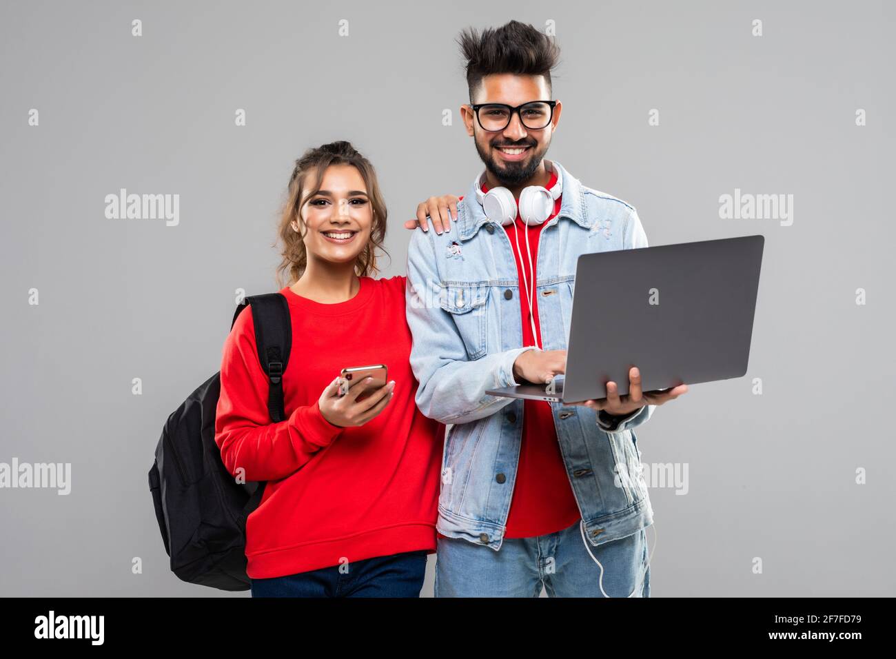 Smiling indian students with a laptop isolated on white background ...