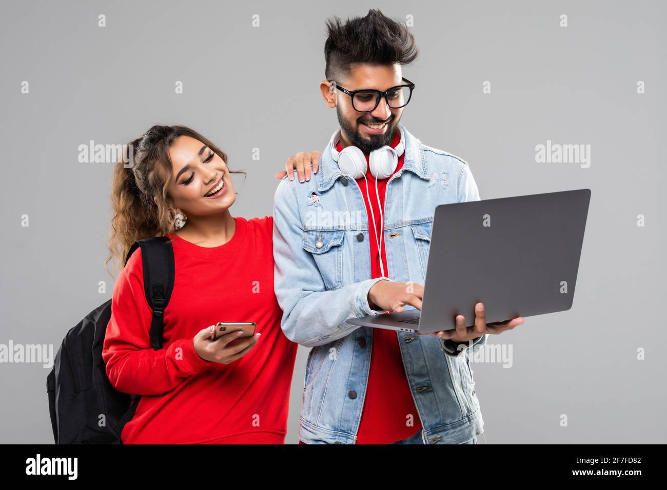 Smiling indian students with a laptop isolated on white background ...