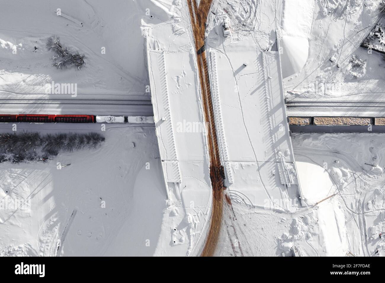Aerial view of cargo train wagons passing under the overpass, a double ...