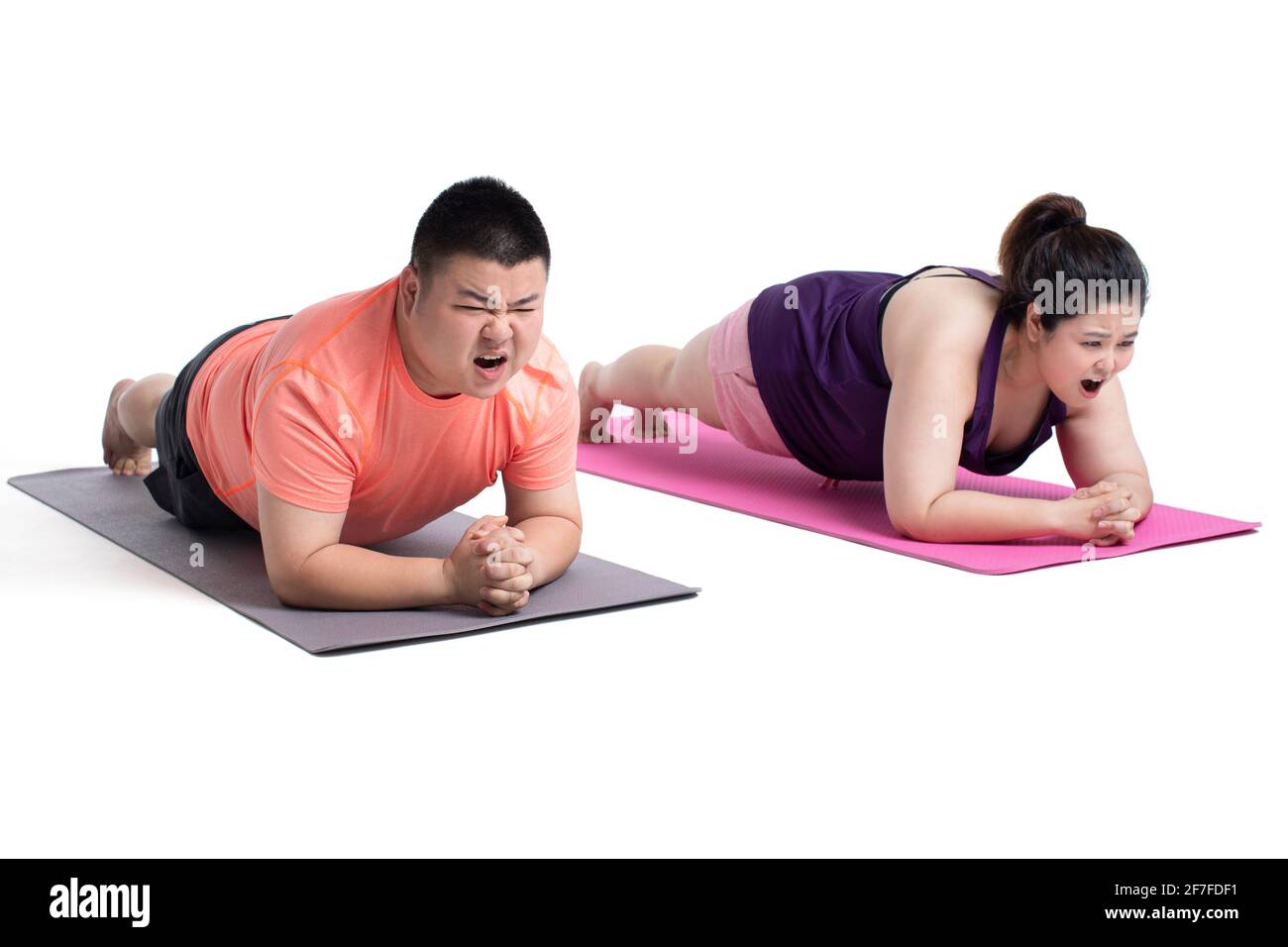 Overweight young couple doing plank position Stock Photo - Alamy
