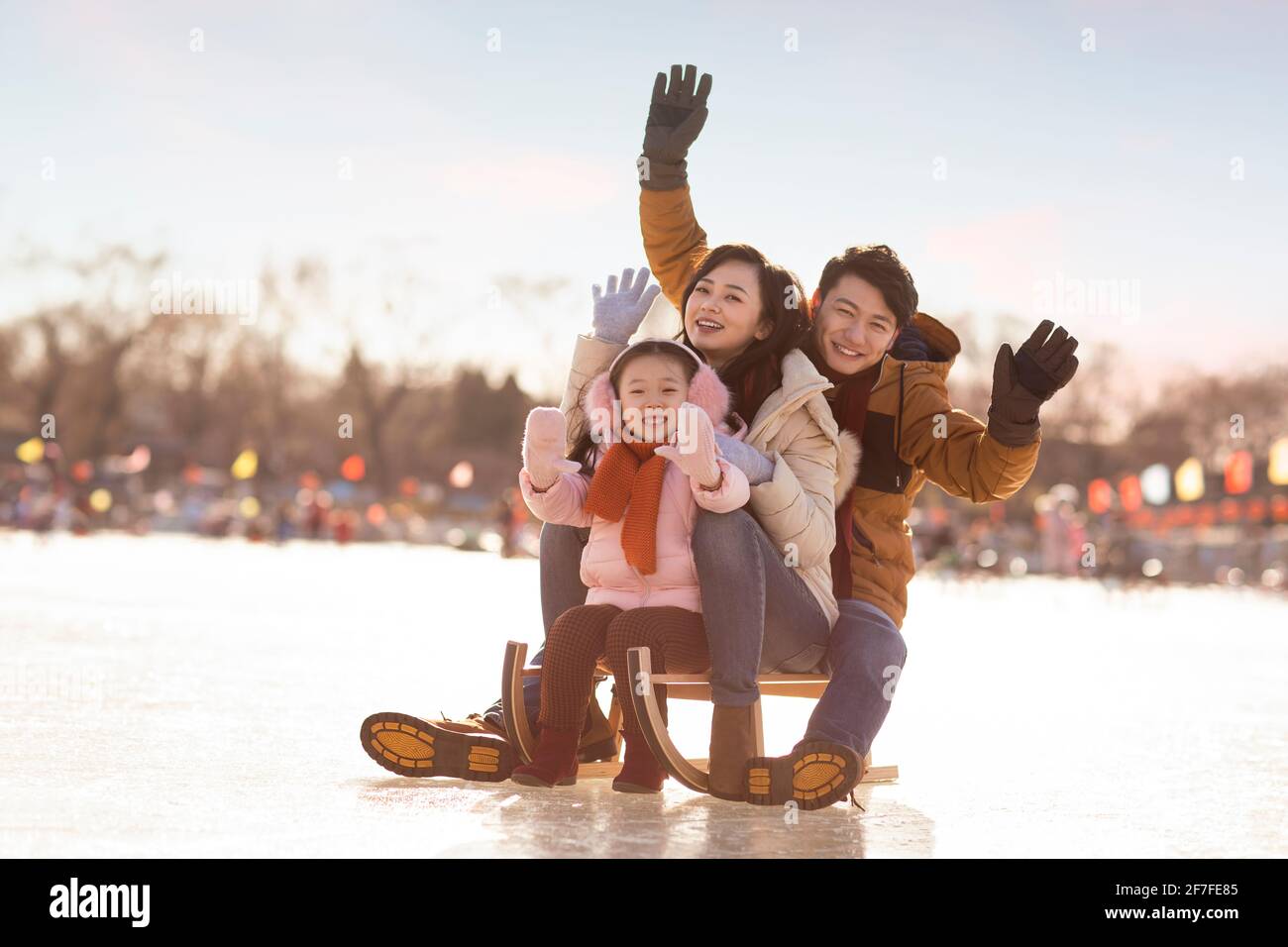Happy young family sledding outdoors Stock Photo - Alamy