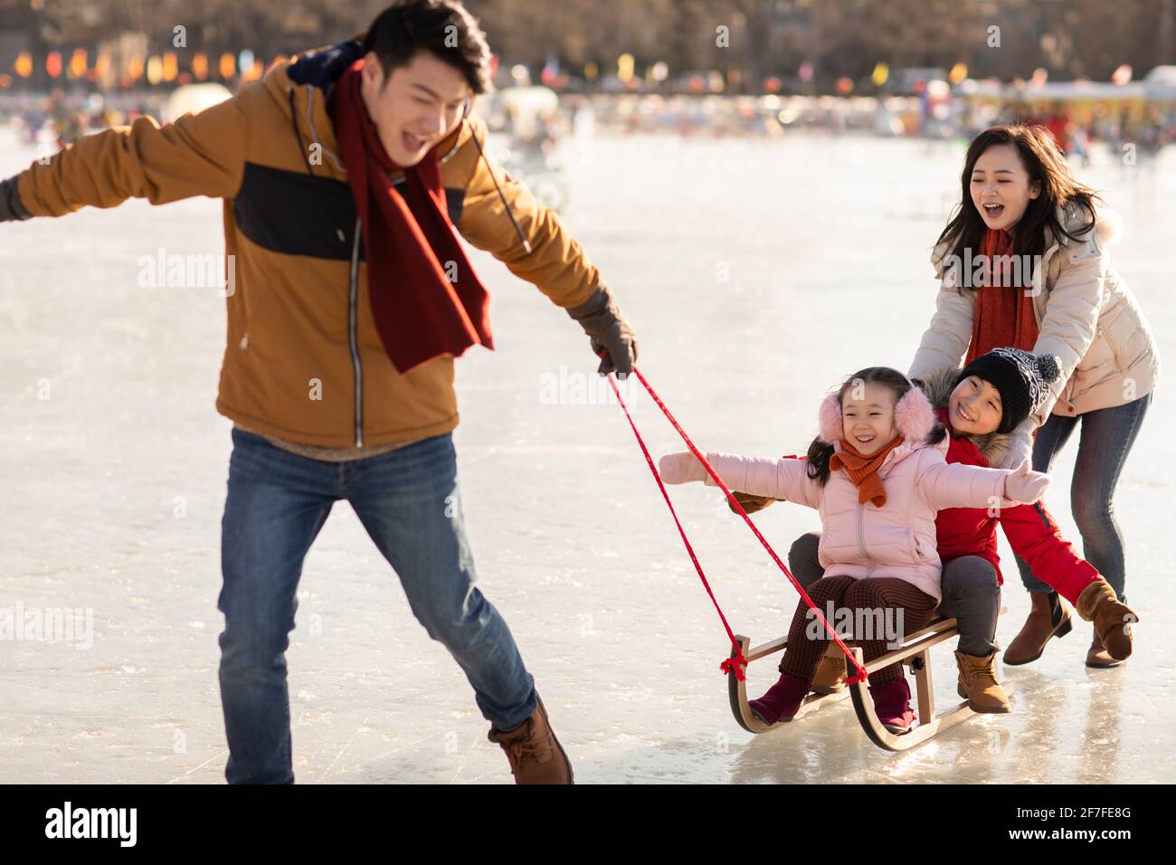 Happy young family sledding outdoors Stock Photo - Alamy