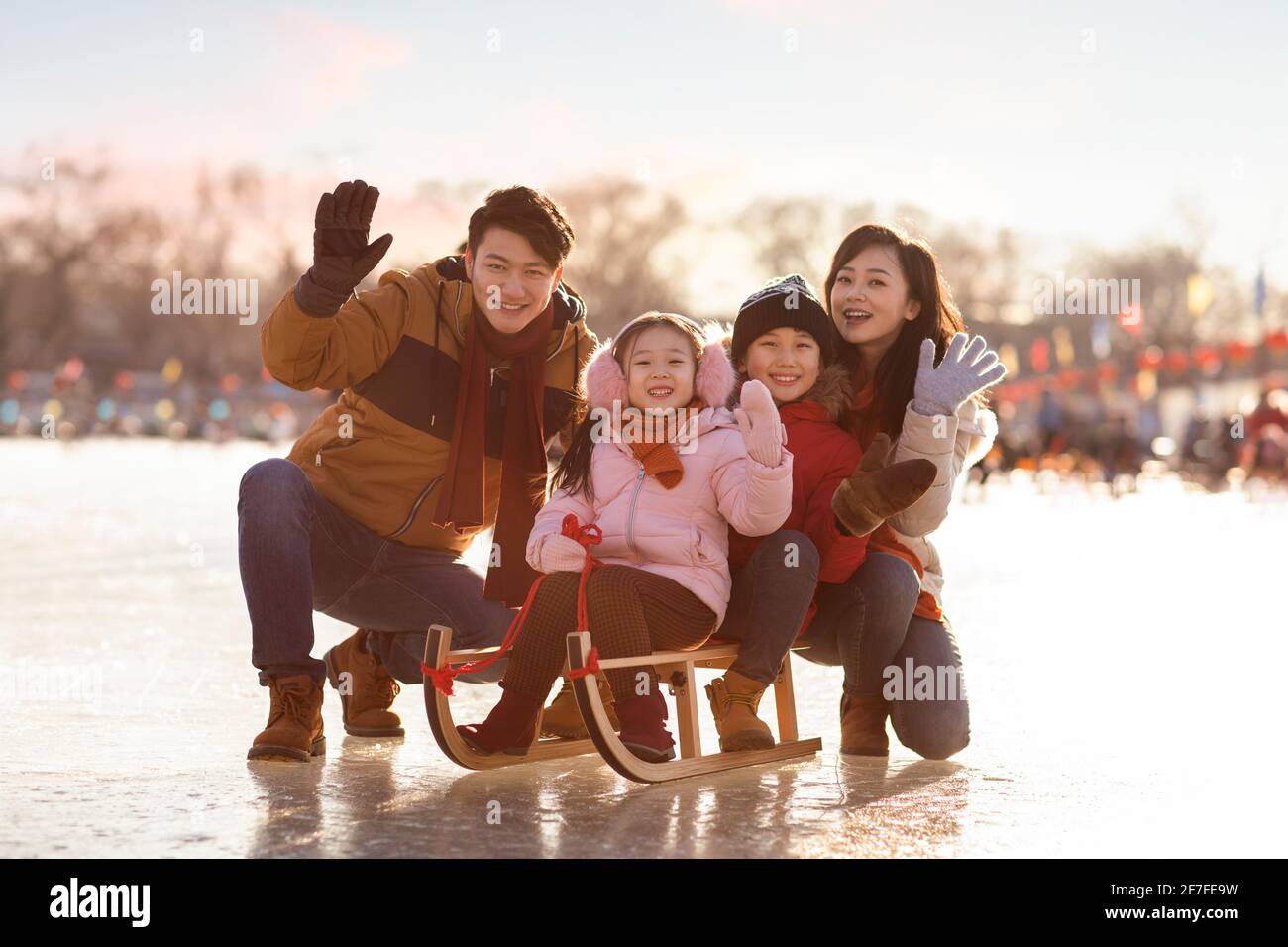 Happy young family sledding outdoors Stock Photo - Alamy