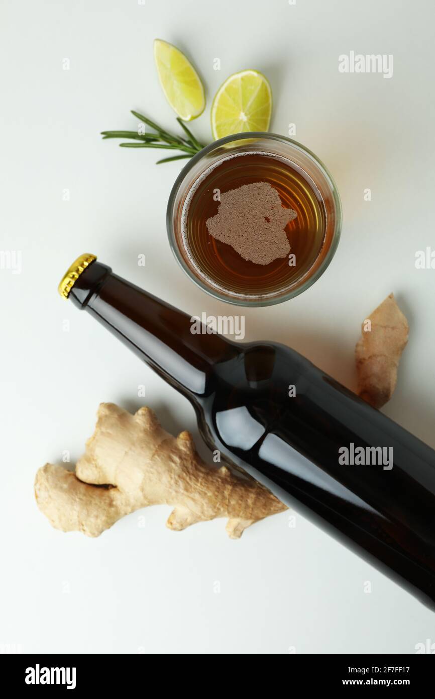 Glass and bottle of ginger beer, and ingredients on white background ...