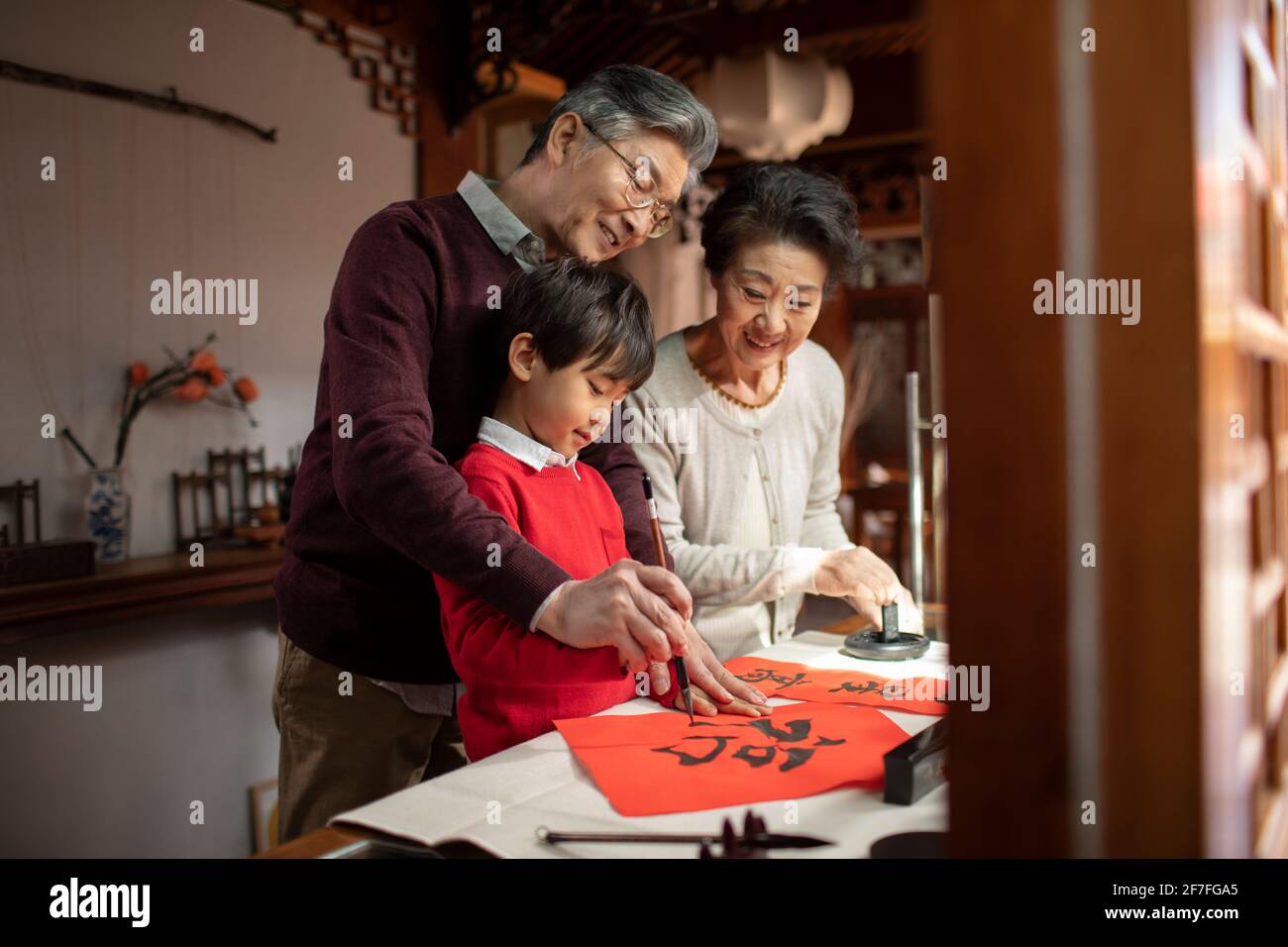 Happy family writing calligraphy on couplets Stock Photo - Alamy