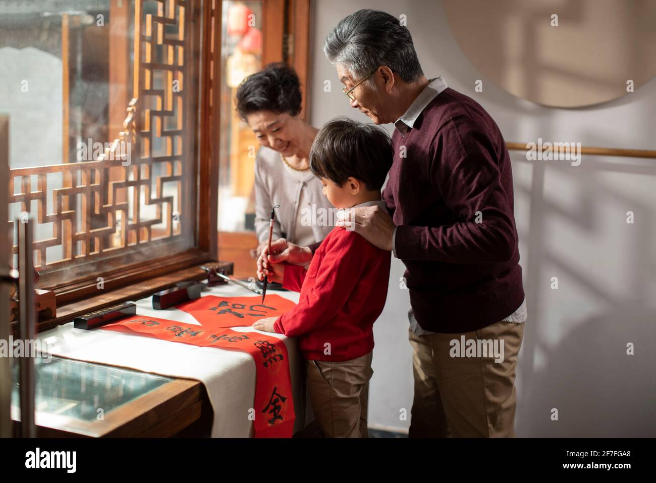 Happy family writing calligraphy on couplets Stock Photo - Alamy