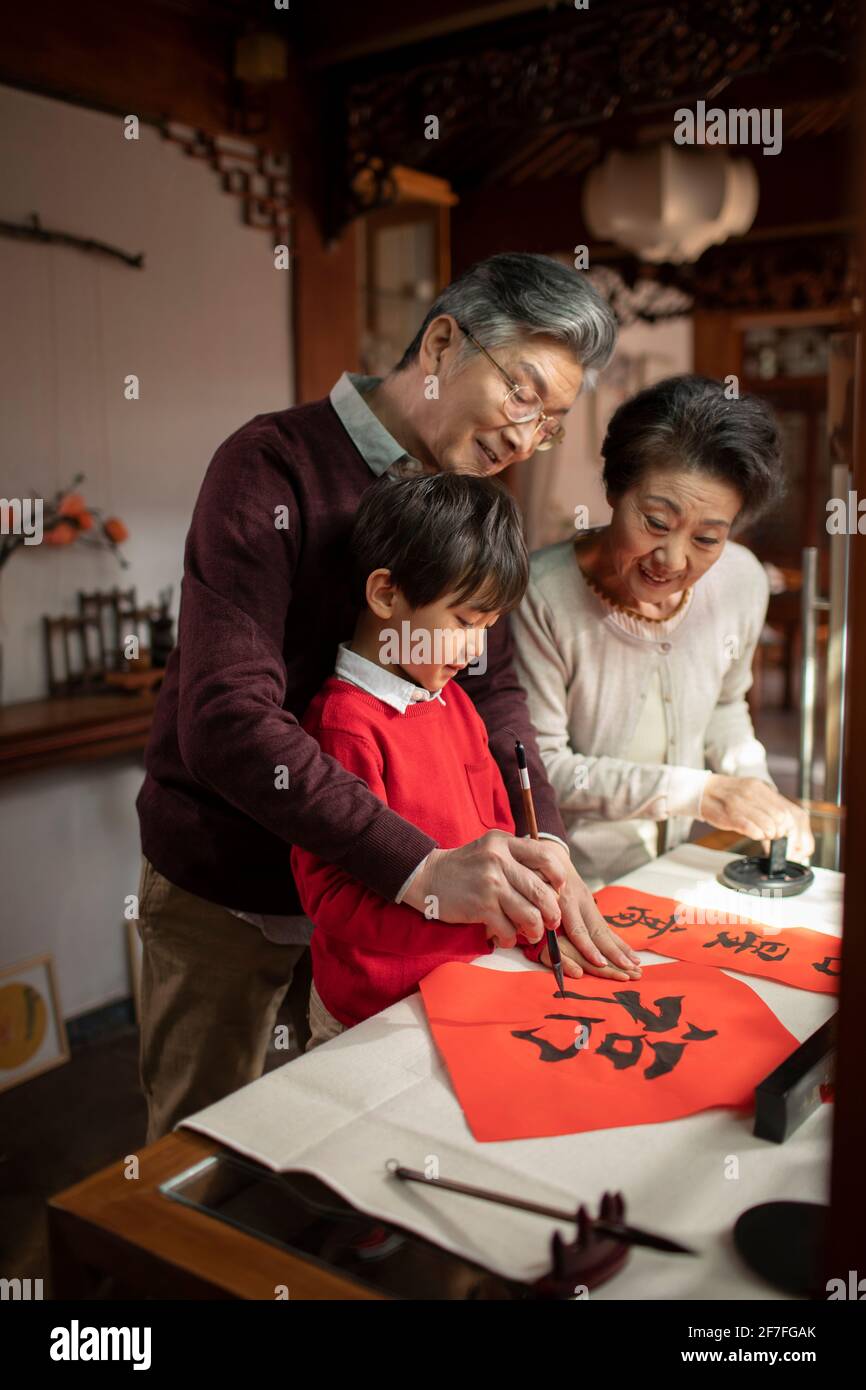 Happy family writing calligraphy on couplets Stock Photo - Alamy