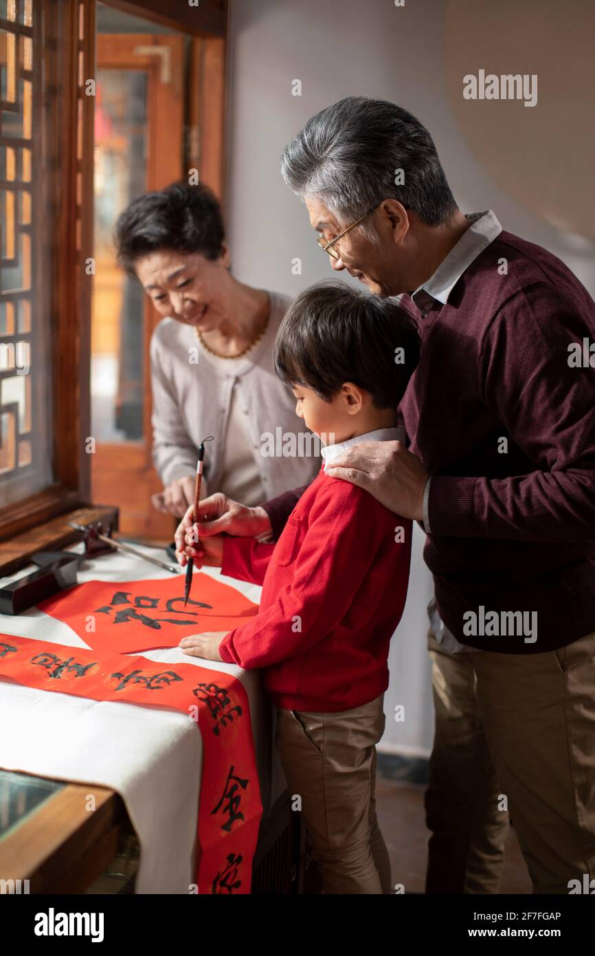 Happy family writing calligraphy on couplets Stock Photo - Alamy