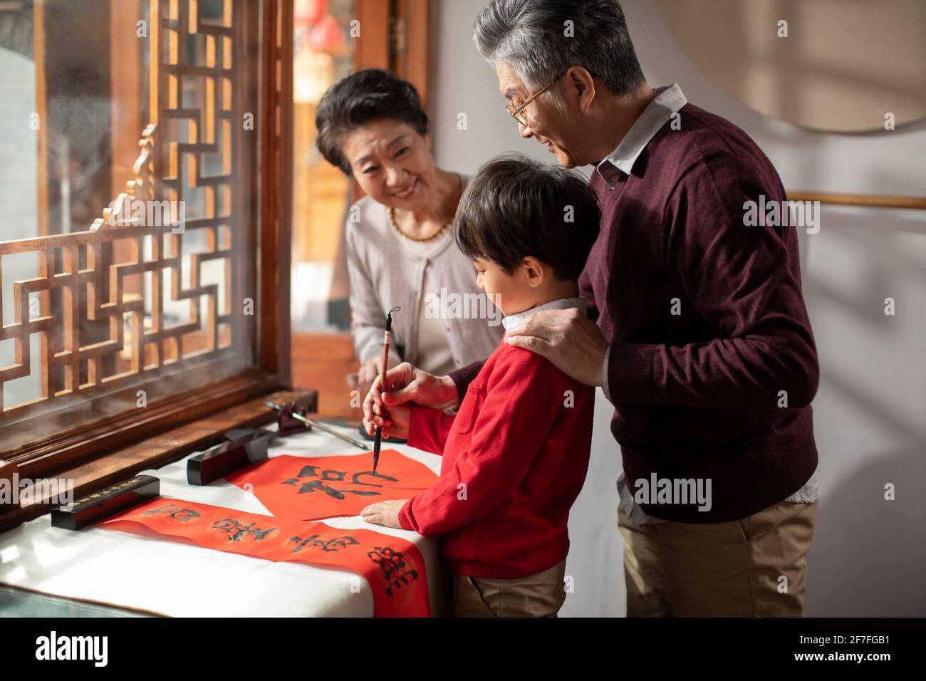 Happy family writing calligraphy on couplets Stock Photo - Alamy