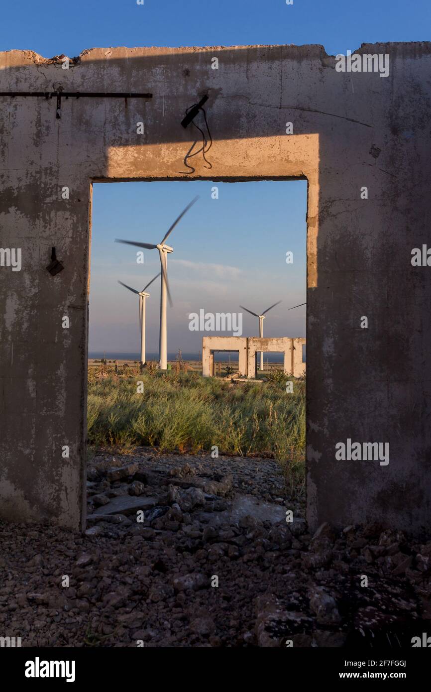 The ruins of a farm of Soviet times against the backdrop of modern wind ...