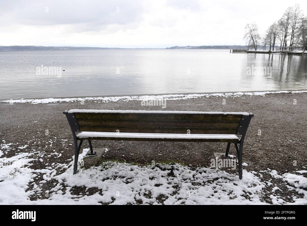 Tutzing, Germany. 07th Apr, 2021. Snow lies next to a park bench near ...