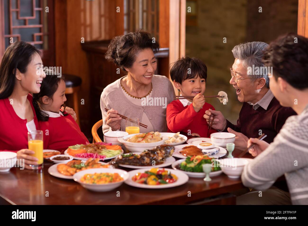 Happy family eating dinner for Chinese New Year Stock Photo - Alamy