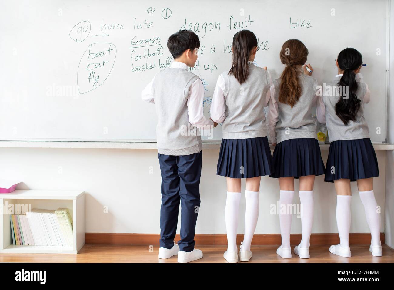 Students writing on whiteboard Stock Photo - Alamy